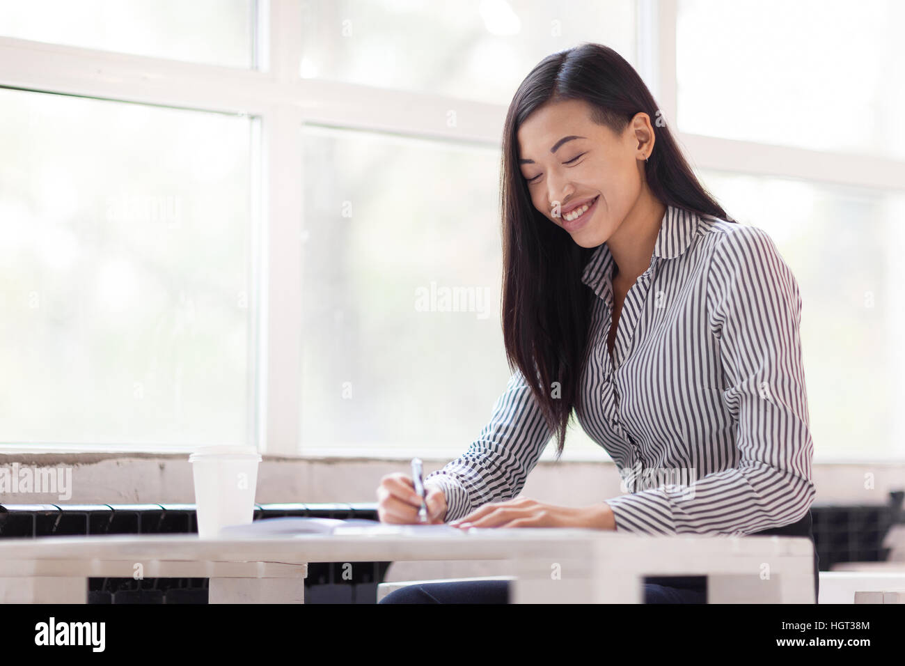 Smiling woman writing plan of her work Stock Photo - Alamy