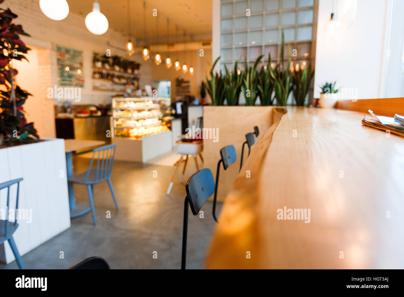 Table and row of chairs in empty cafe Stock Photo - Alamy