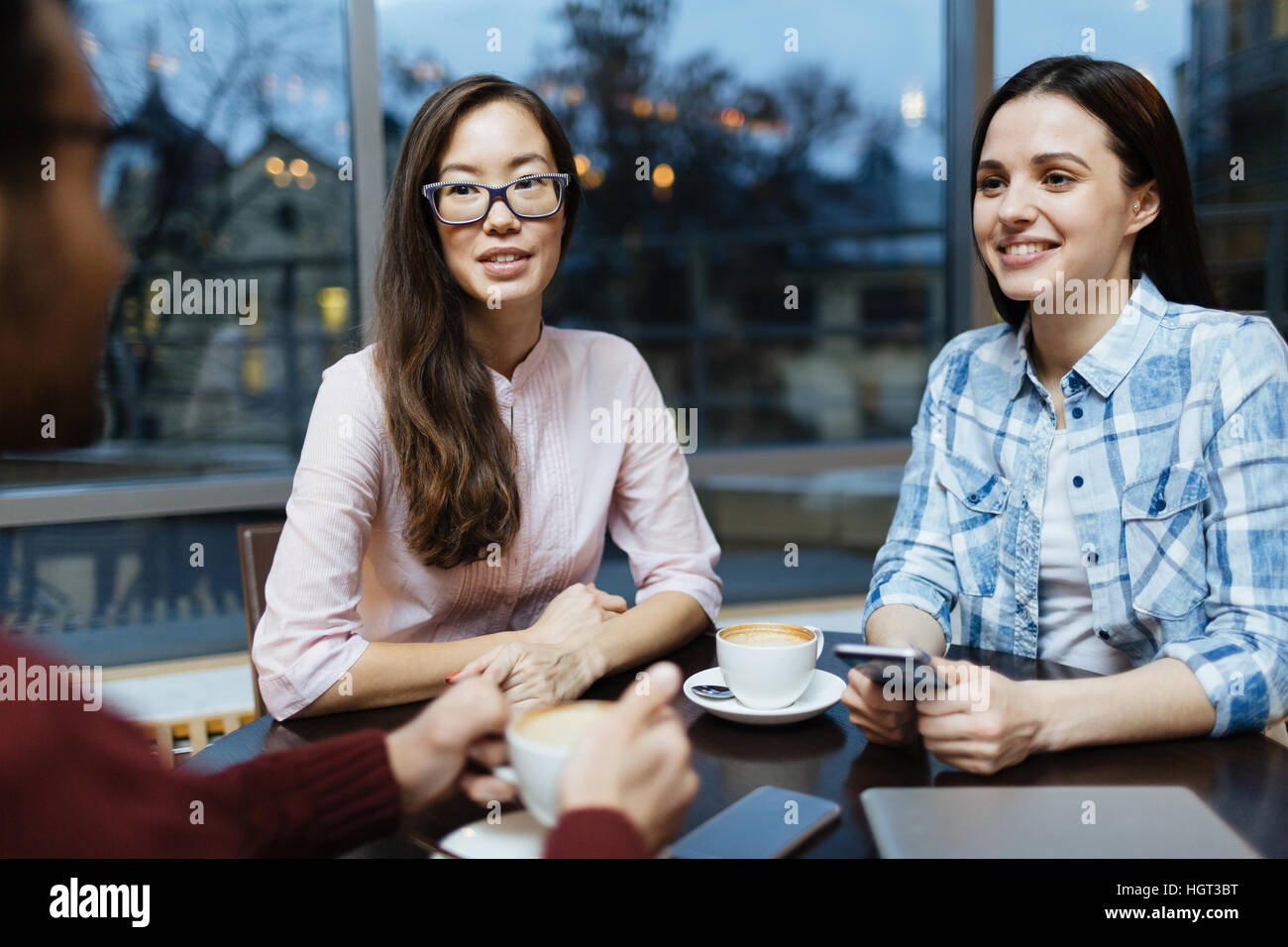 Friendly people having conversation in cafe Stock Photo - Alamy