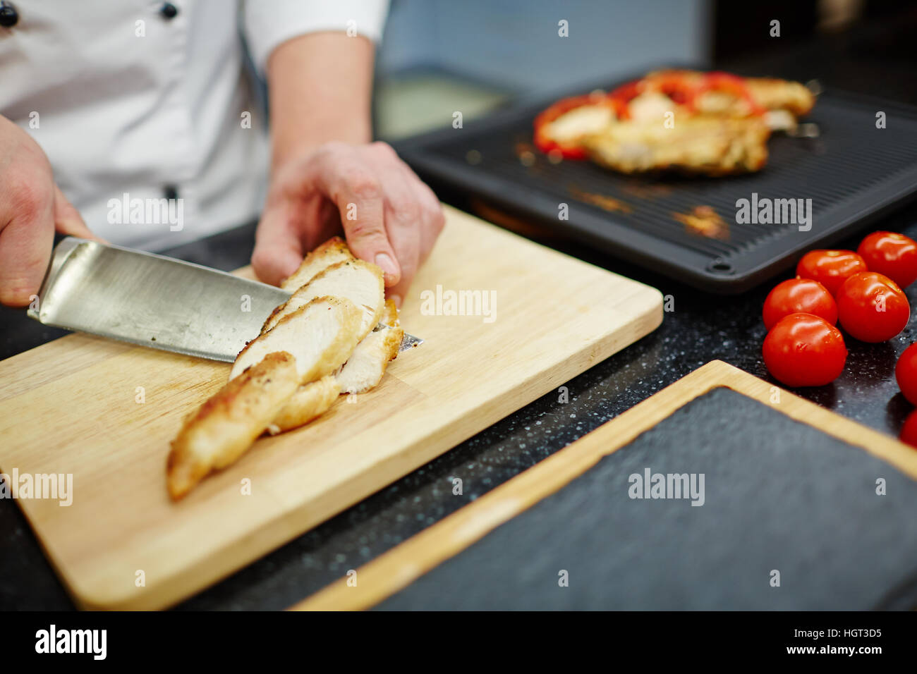 Chief cutting roasted chicken steak with sharp knife Stock Photo - Alamy