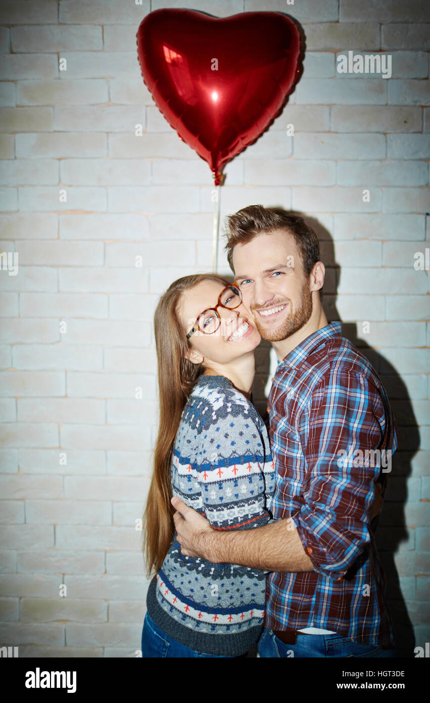 Amorous man and woman with balloon standing in hug Stock Photo - Alamy