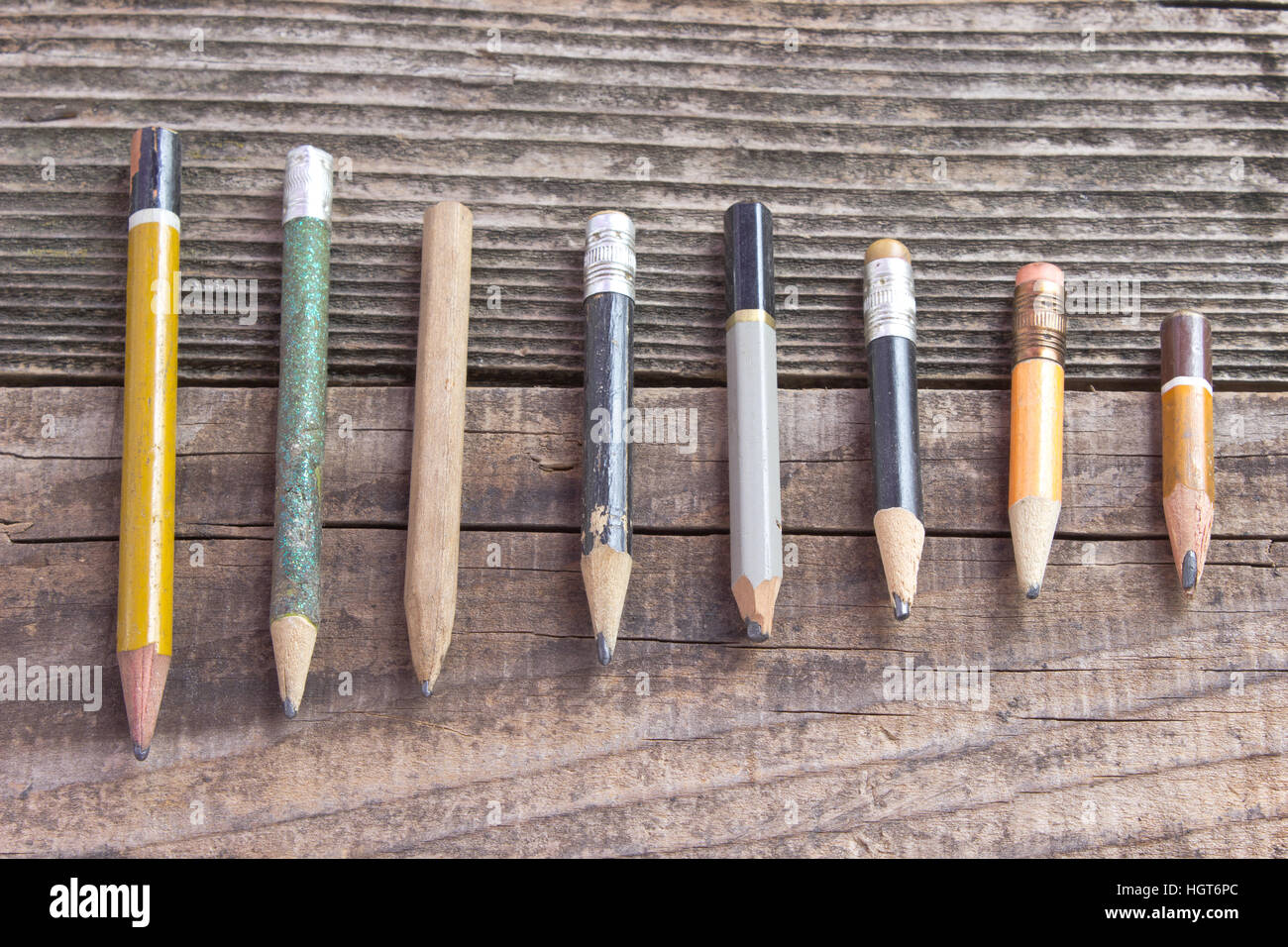 Used wooden pencils on wooden background Stock Photo - Alamy