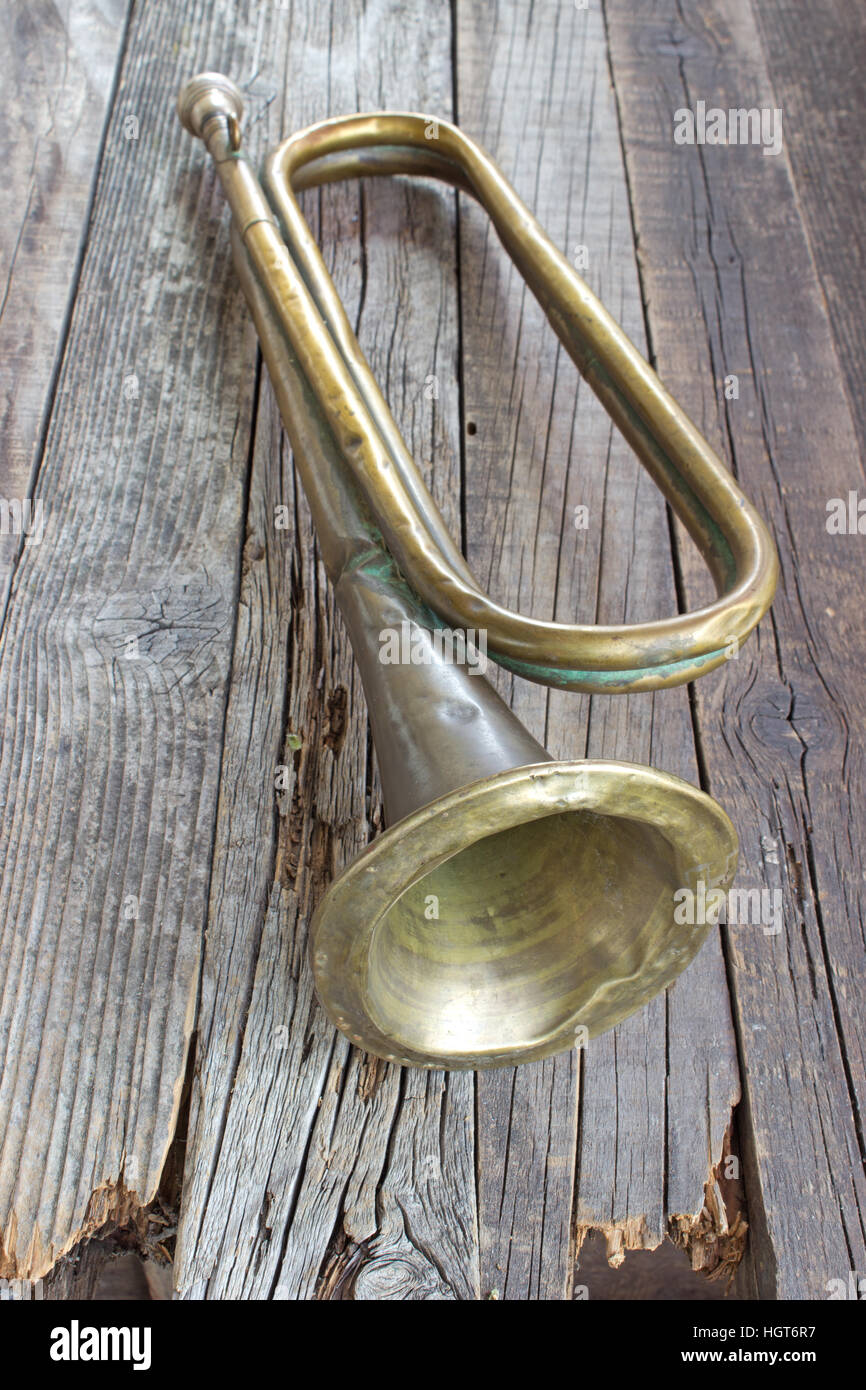 Old broken army trumpet on wooden background Stock Photo - Alamy
