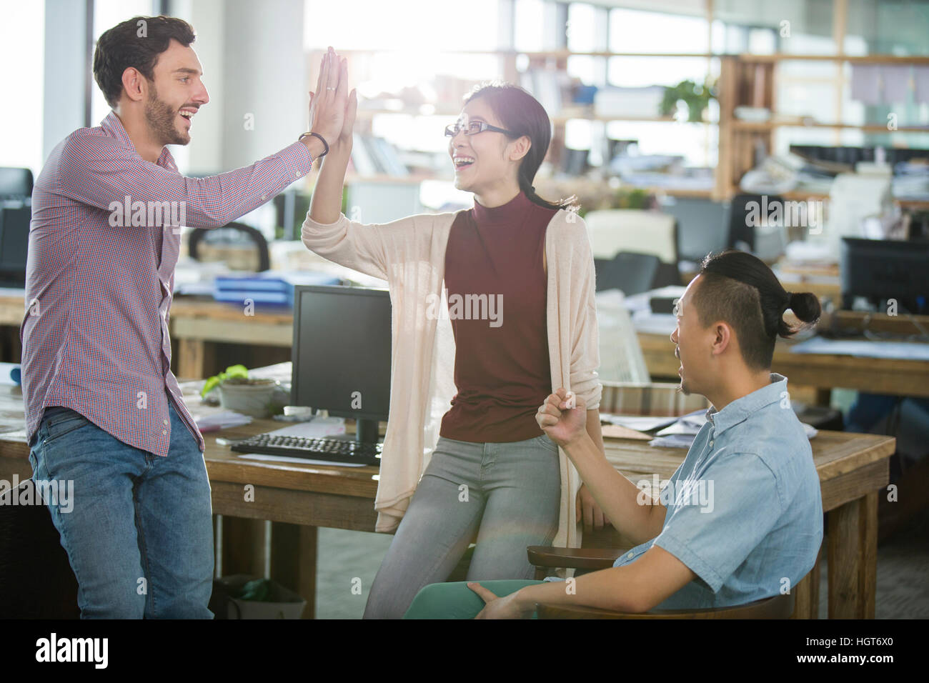 Architects high fiving in the office Stock Photo - Alamy