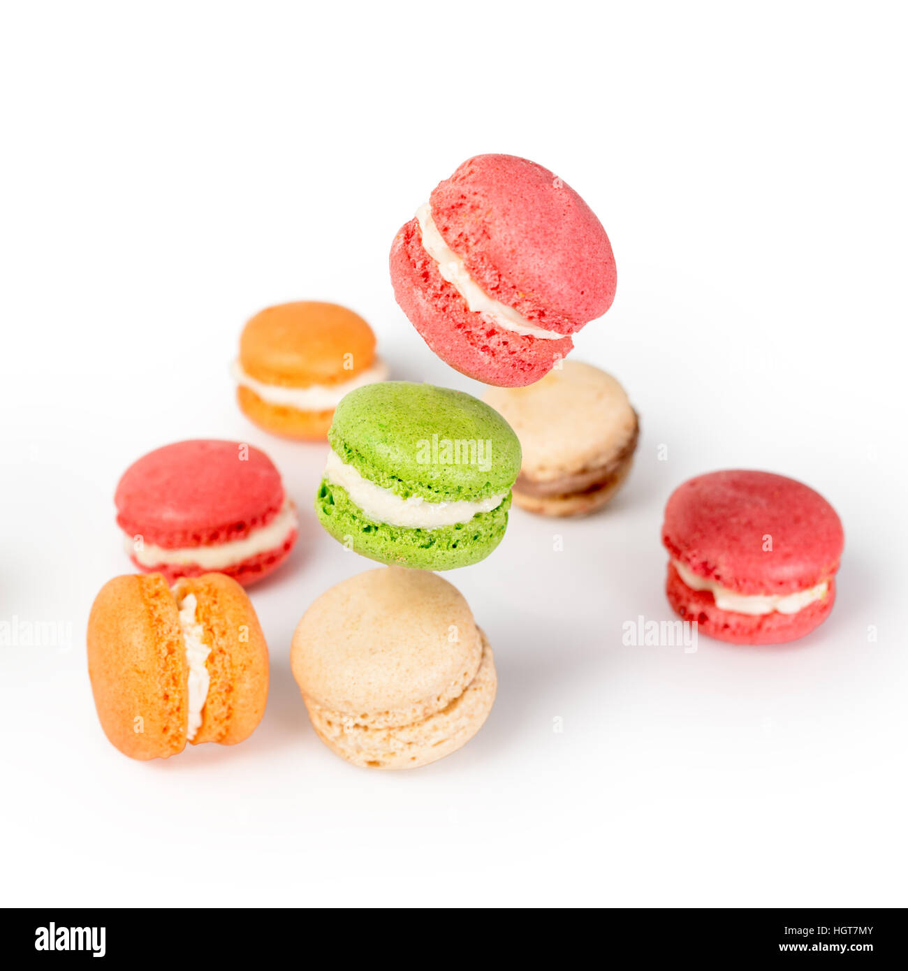 Different types of macaroons in motion falling or flying on white ...