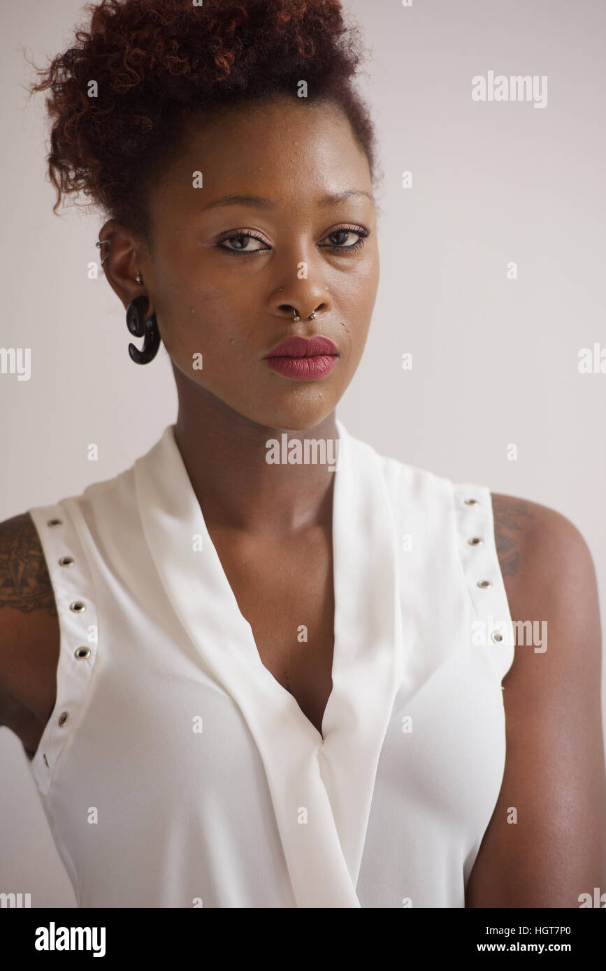 Beautiful young African woman in a white outfit, indoors Stock Photo ...