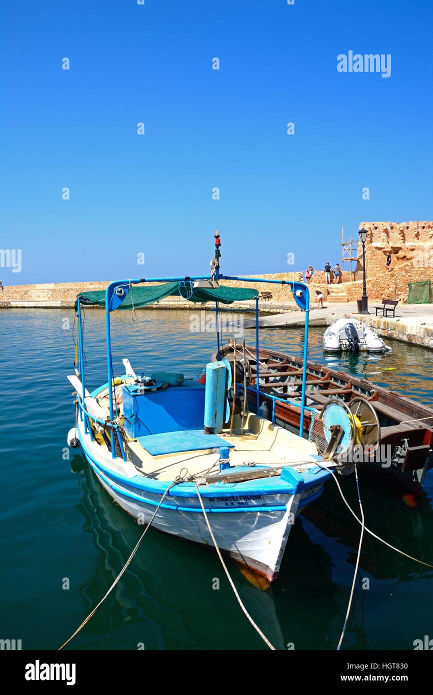 Traditional fishing boat in the harbour with the harbour wall to the ...