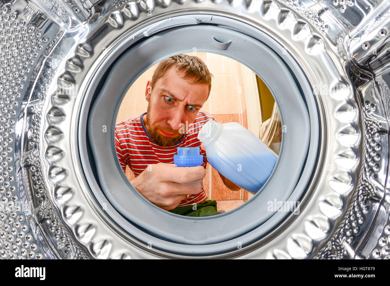 Man Doing Laundry Reaching Inside Washing Machine Stock Photo - Alamy
