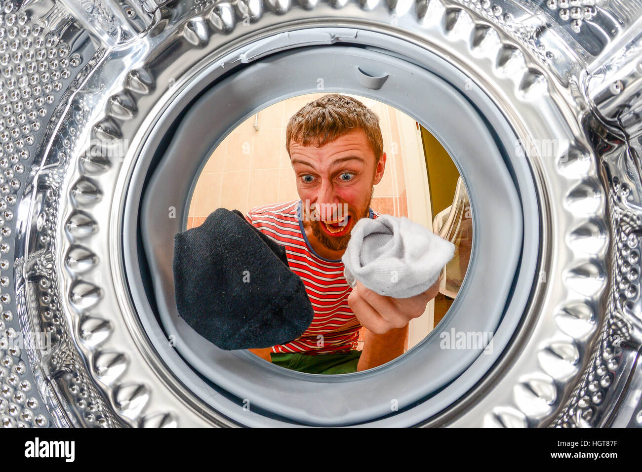 Man Doing Laundry Reaching Inside Washing Machine Stock Photo - Alamy