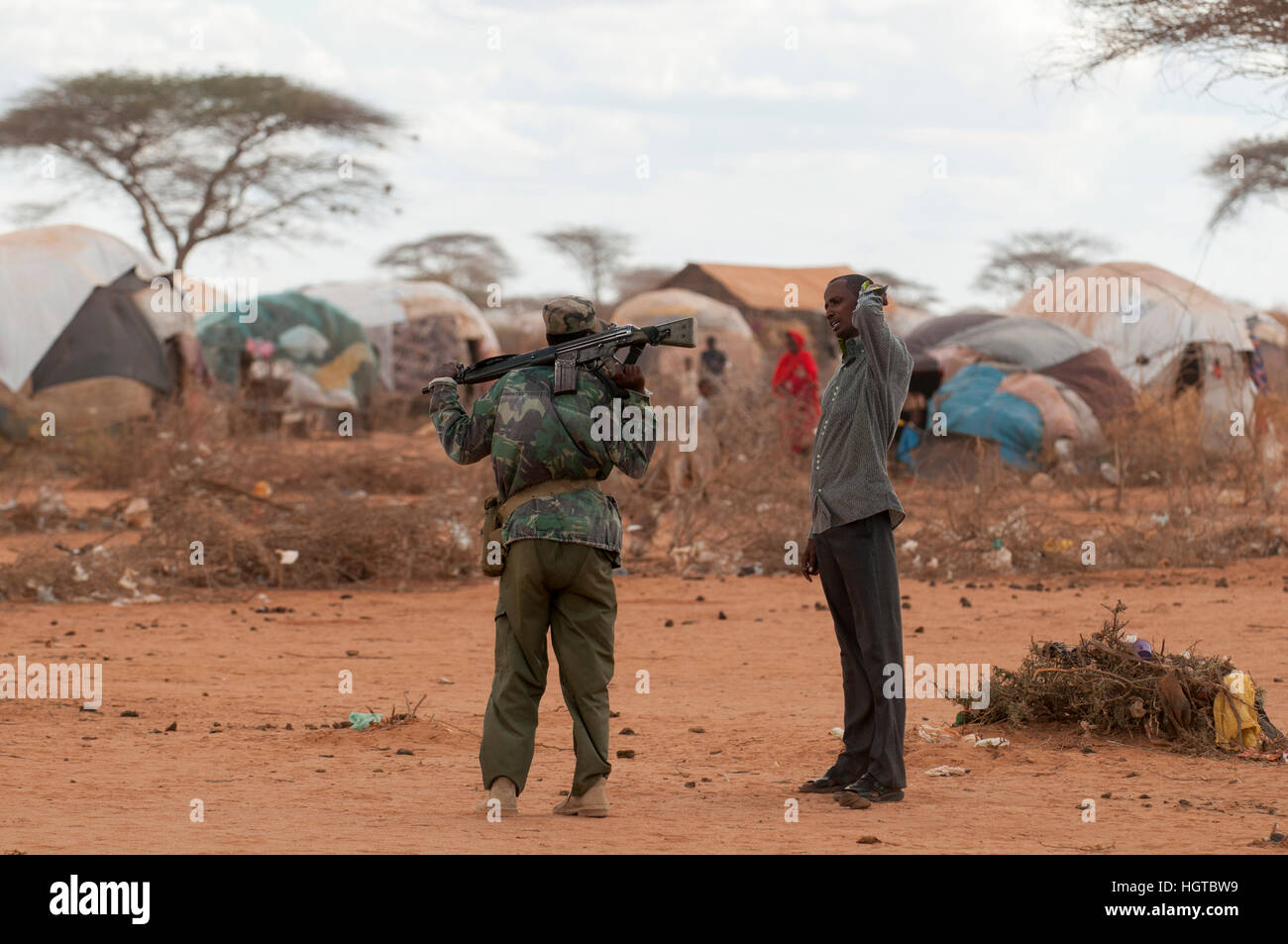 A security guard watching Somalian refugees living in temporary makeshift shelters at the Dadaab ...