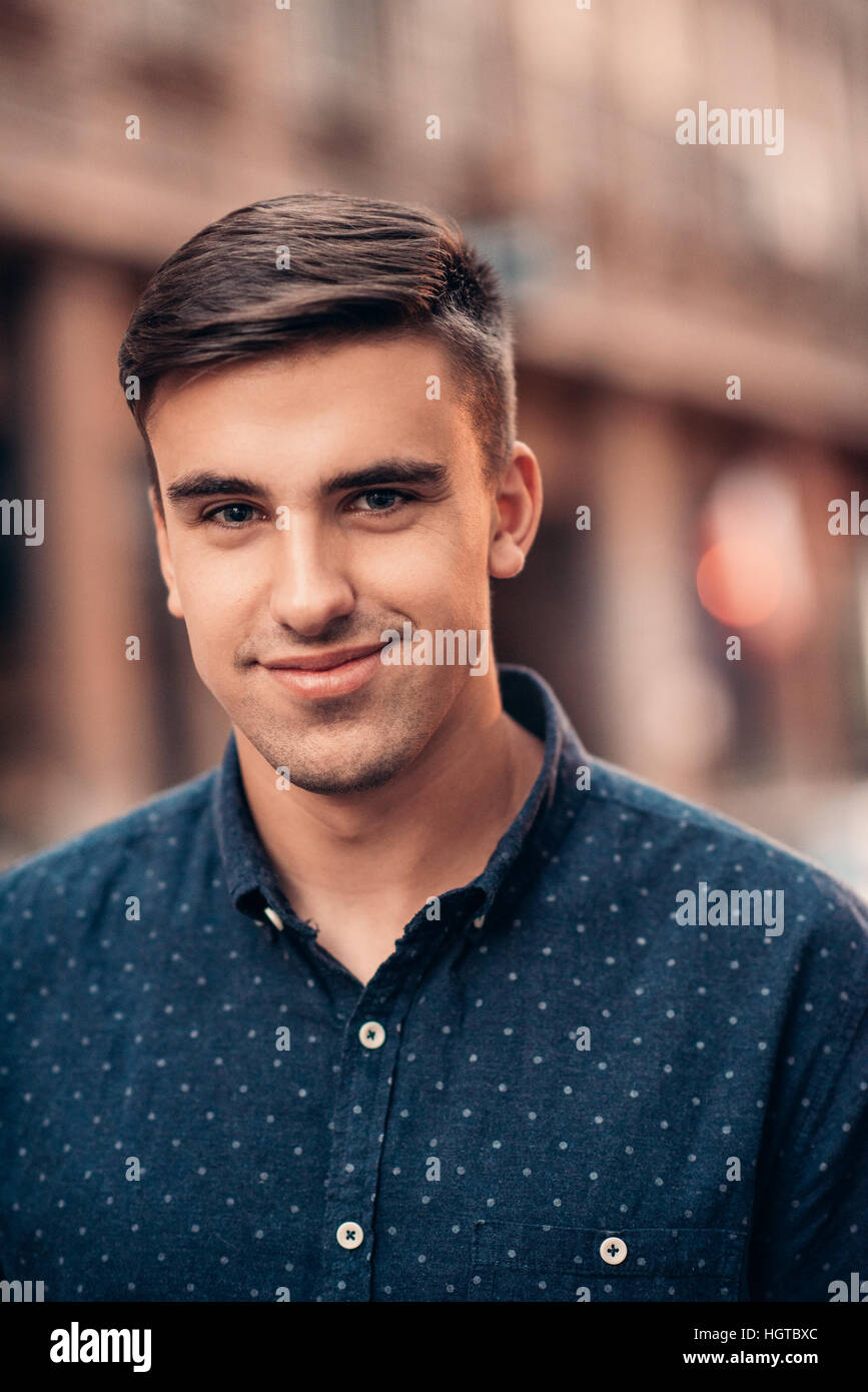 Young man smiling on a city street Stock Photo - Alamy
