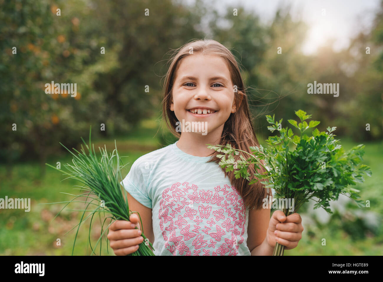 Cute little girl holding herbs outside Stock Photo - Alamy