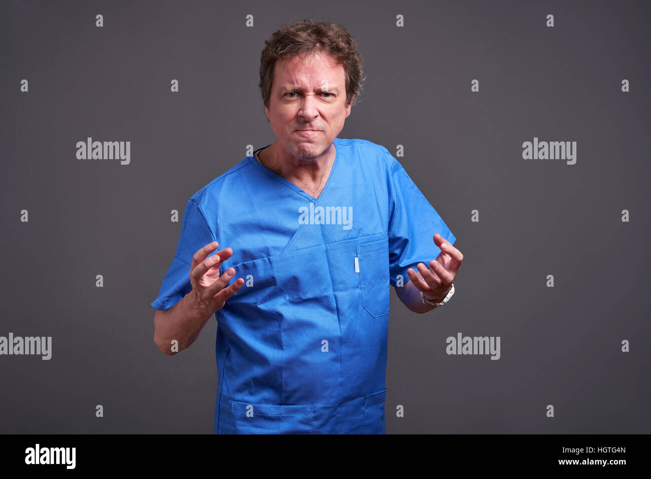 A middle aged male doctor standing and feeling angry Stock Photo - Alamy