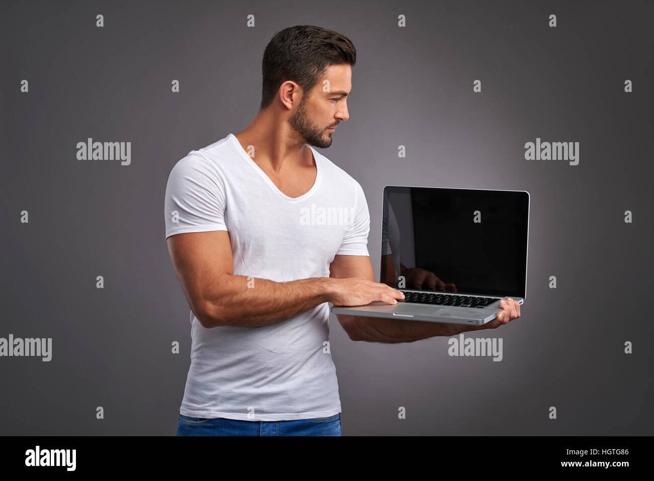 A handsome young man holding and showing the screen of a laptop Stock ...