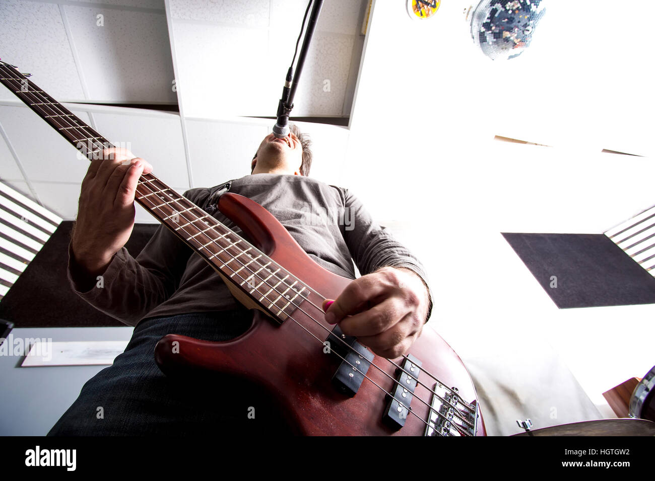 A Rock musician playing passionately bass in the rehearsal Studio Stock ...
