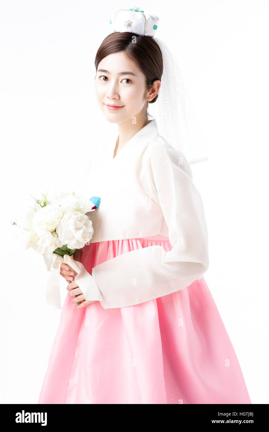 Young smiling bride in traditional Korean clothes posing with bouquet ...