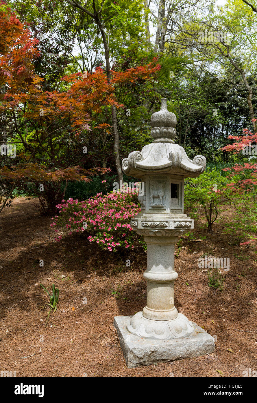 Stone sculpture in a lush green japanese garden Stock Photo - Alamy