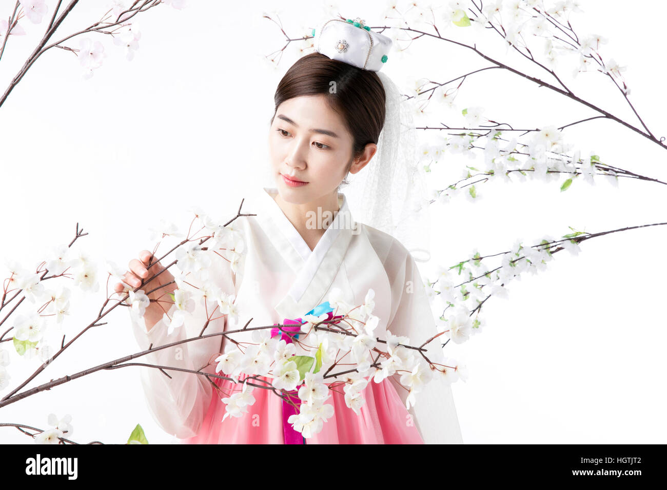 Portrait of young woman in traditional Korean clothes touching spring ...