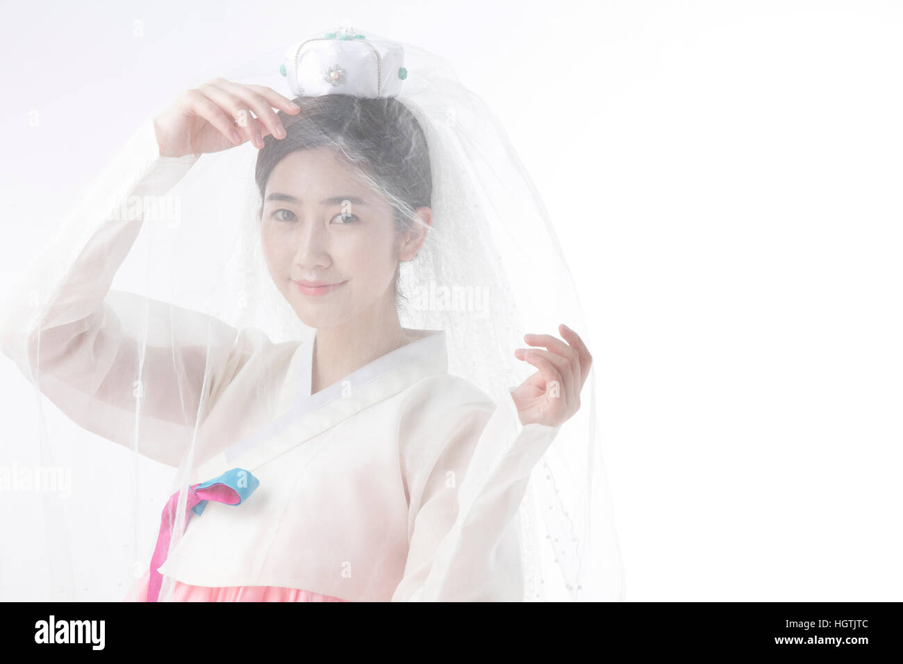 Portrait of young bride in traditional Korean clothes and wedding veil ...