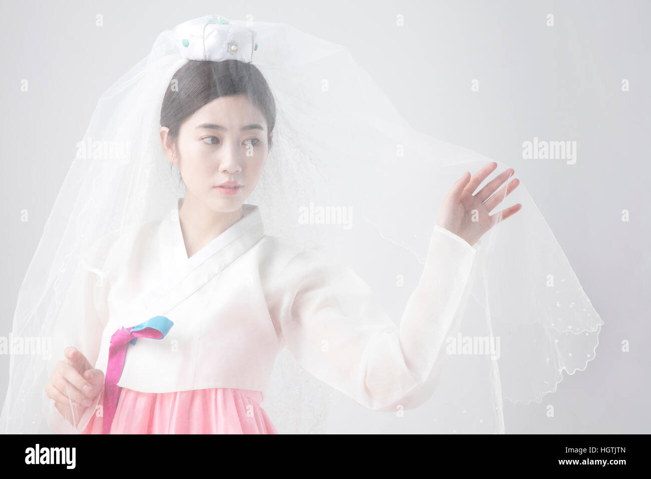Portrait of young bride in traditional Korean clothes and wedding veil ...