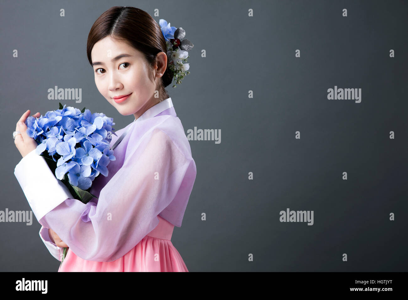 Side view portrait of young smiling woman in traditional Korean clothes ...