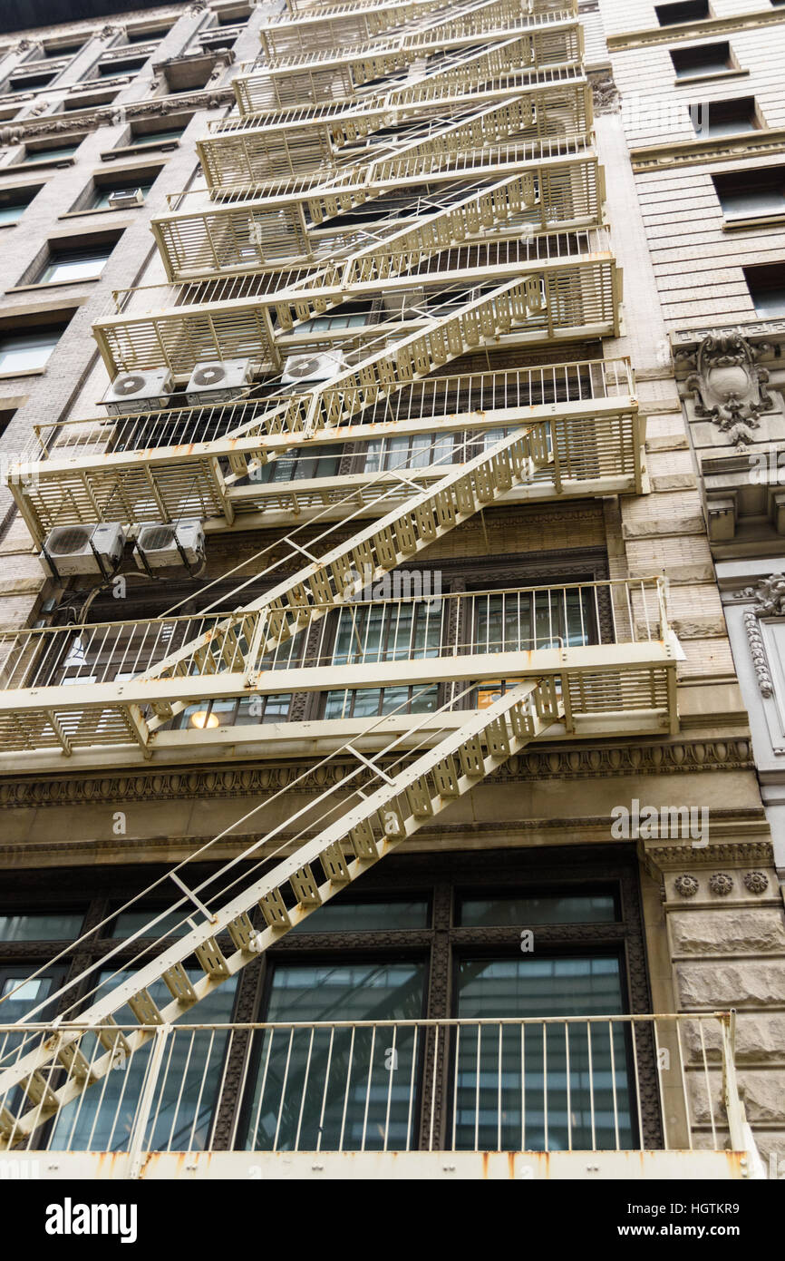 Abstract view looking up at fire escape ladders on the side of a New ...