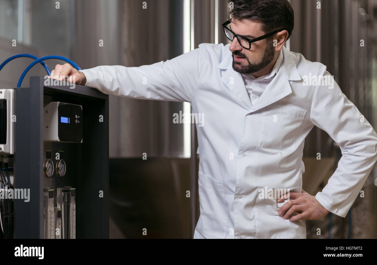 Handsome man controlling brewing mechanism Stock Photo - Alamy