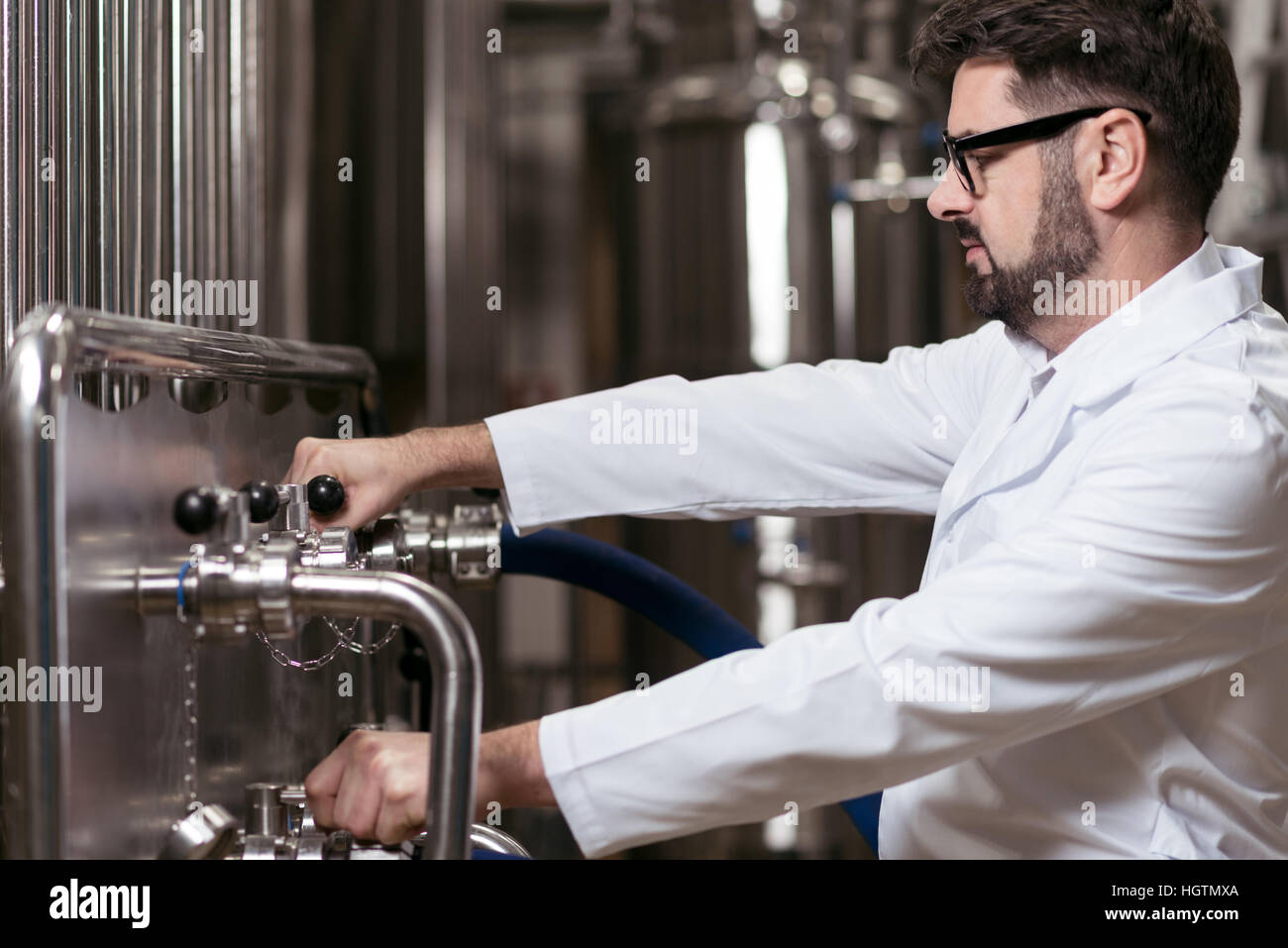 Delighted man making beer in brewery Stock Photo - Alamy