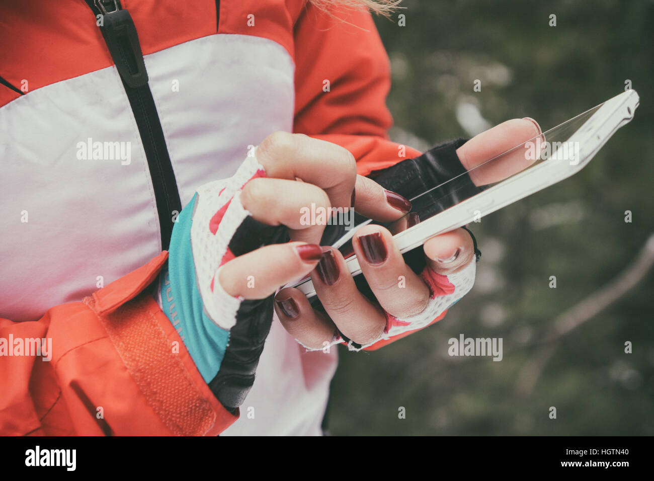 Female hand with mobile phone and gloved hands Stock Photo - Alamy