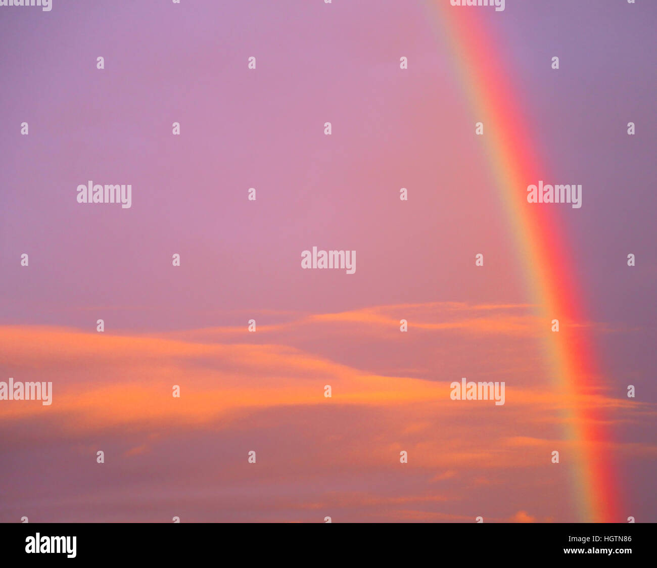 beautiful rainbow at sunset with sky and clouds Stock Photo - Alamy