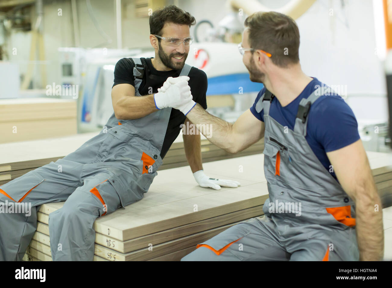Young male workers in a furniture factory taking a rest Stock Photo - Alamy