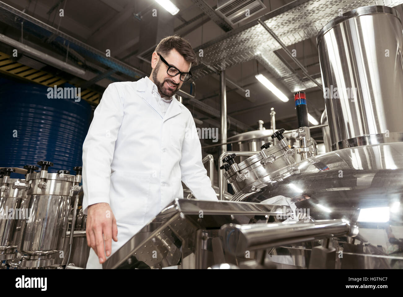 Smiling man looking at brewing mechanism Stock Photo - Alamy