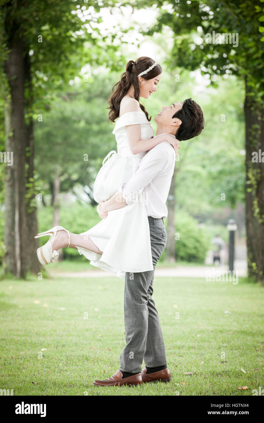Side view of young romantic couple holding face to face outdoors Stock ...