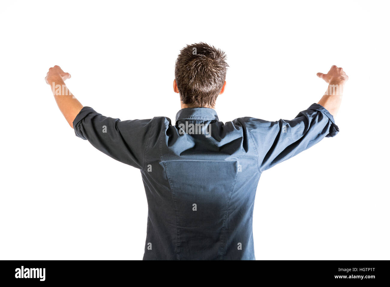 young man wearing blue shirt with arms open against white background ...
