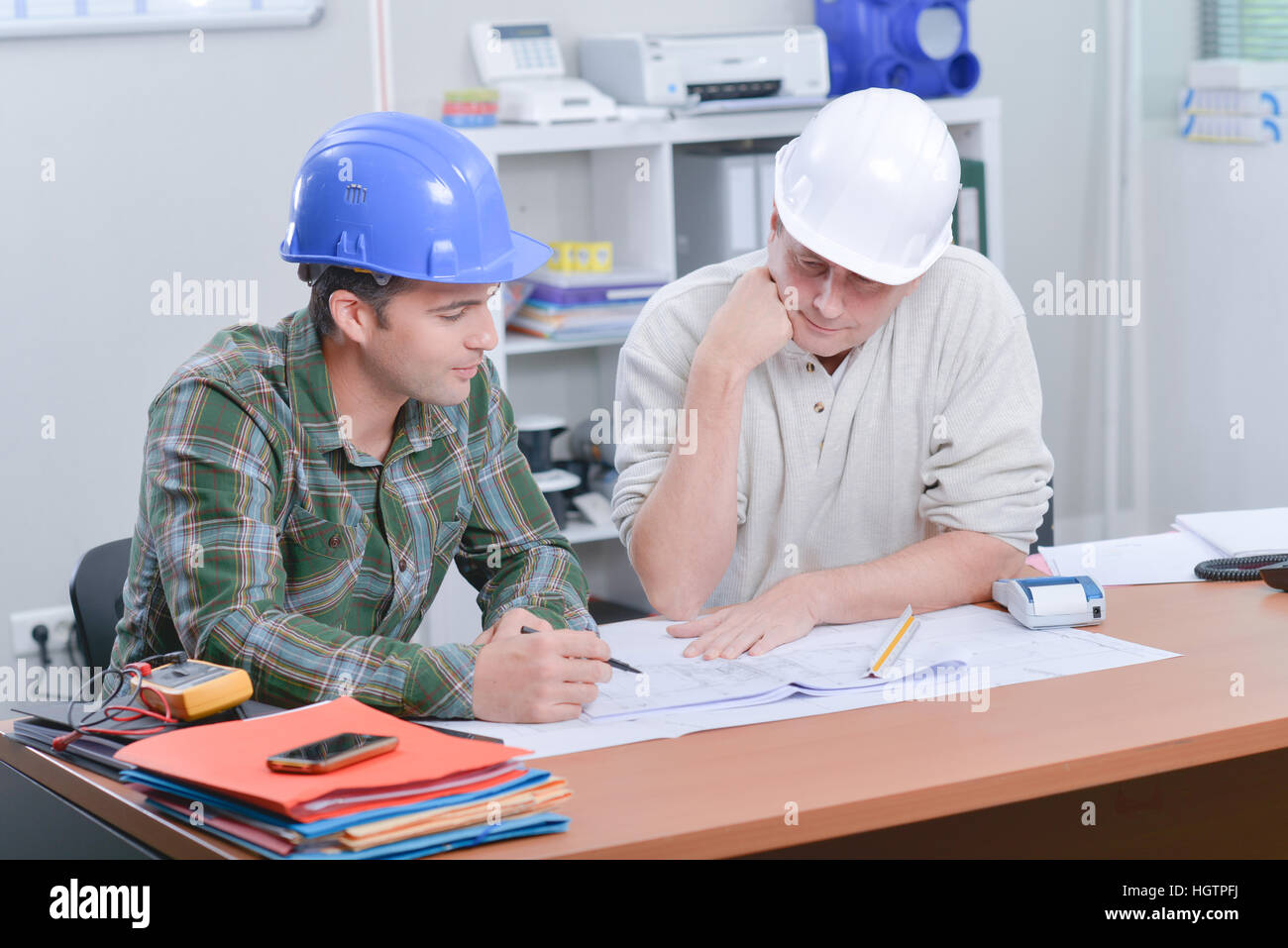 Two architects looking over plans Stock Photo - Alamy