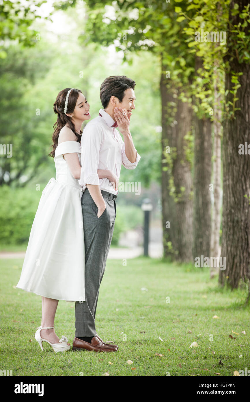 Side view of young romantic wedding couple outdoors Stock Photo - Alamy