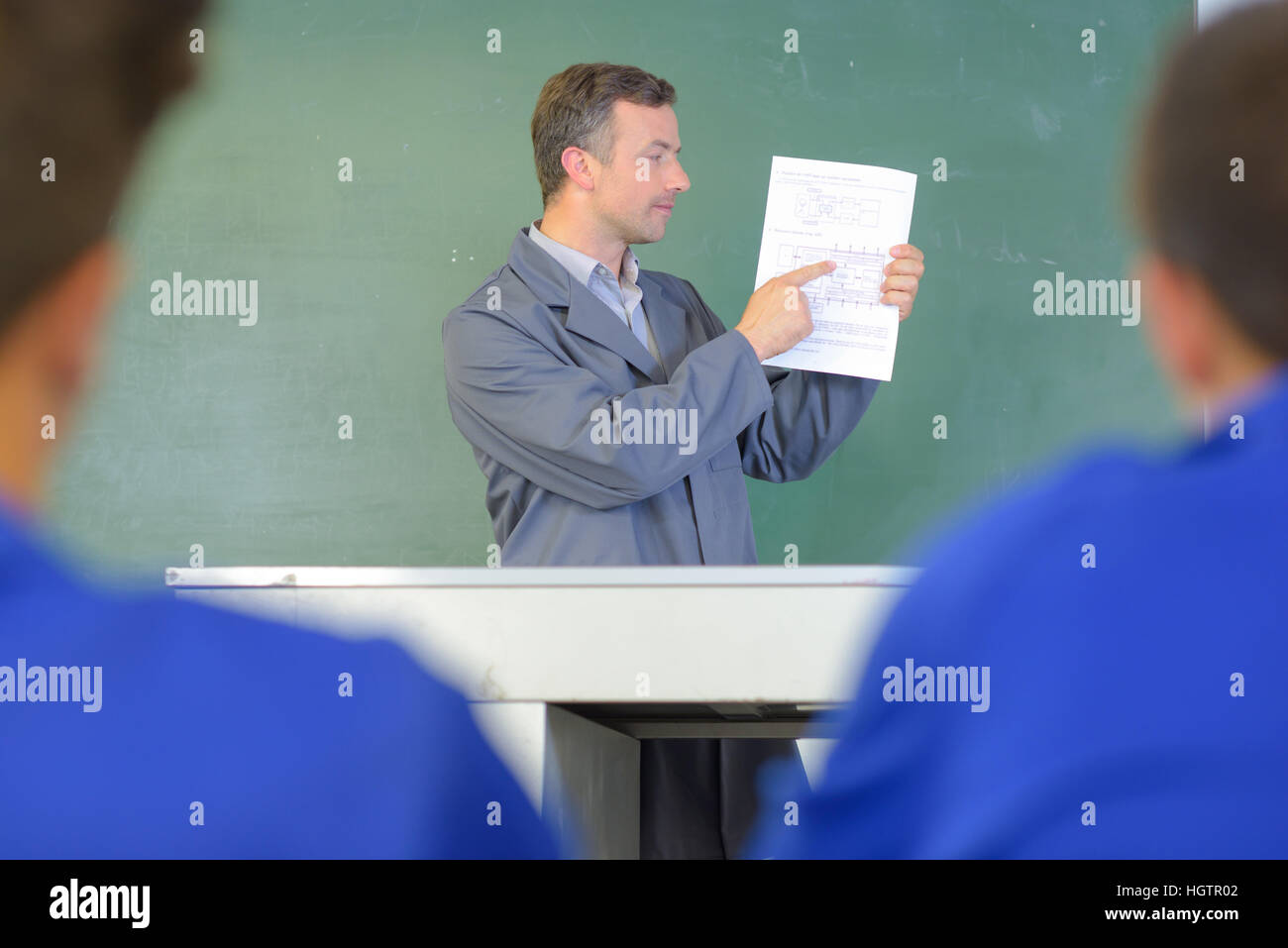 Teacher pointing to paperwork Stock Photo - Alamy