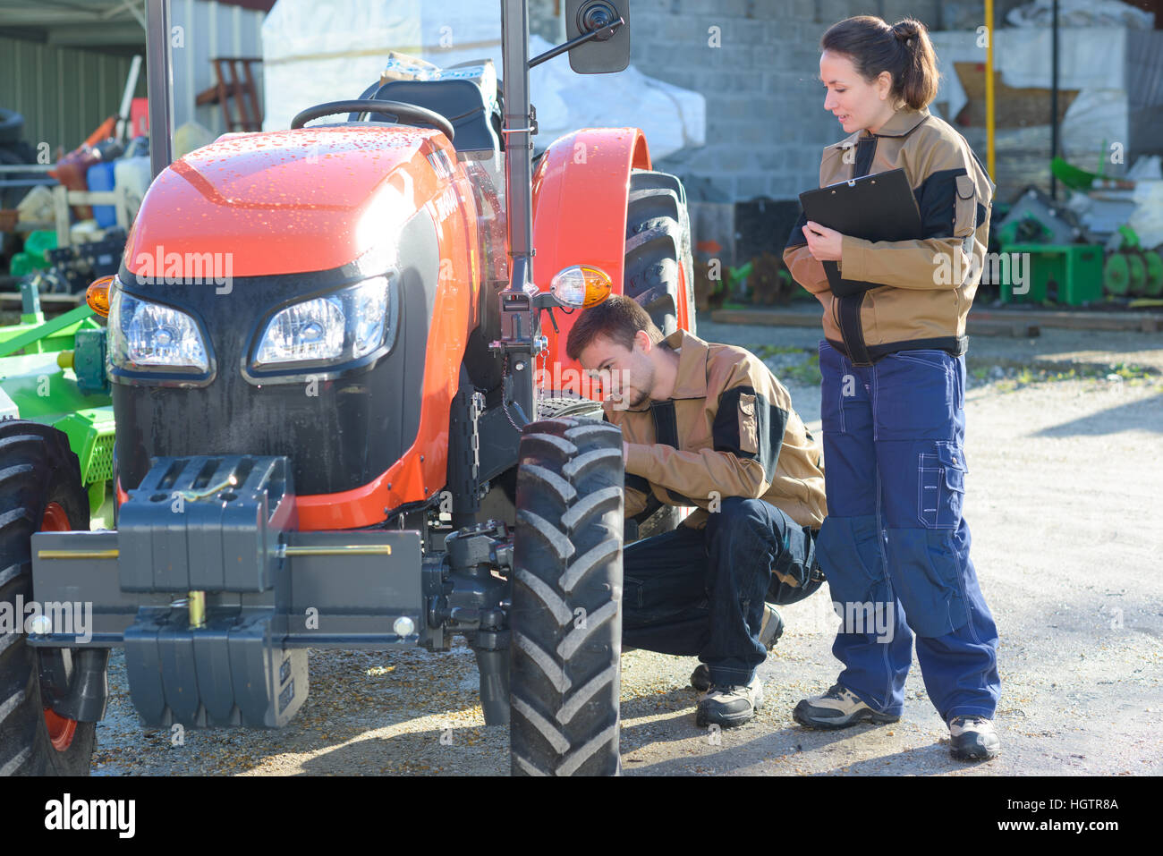 agricultural mechanics checking tractors condition before harvesting ...