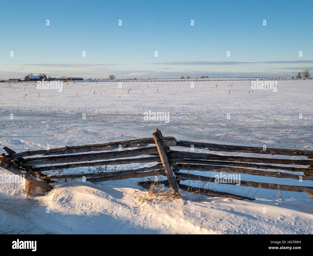 Sun Over Snow covered field with cedar rail fence in winter Stock Photo ...