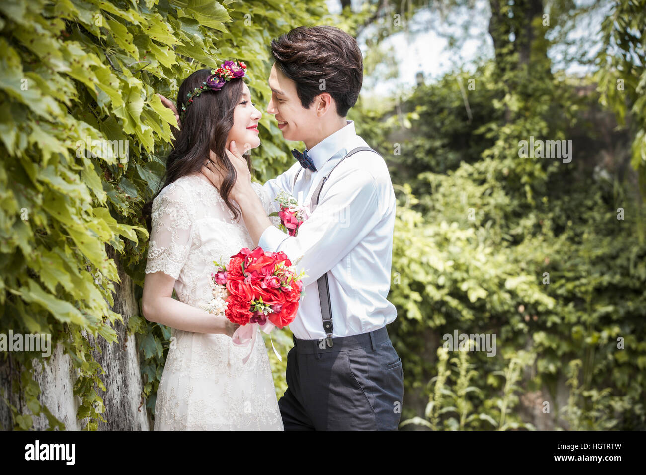 Side view of romantic wedding couple posing outdoors Stock Photo - Alamy