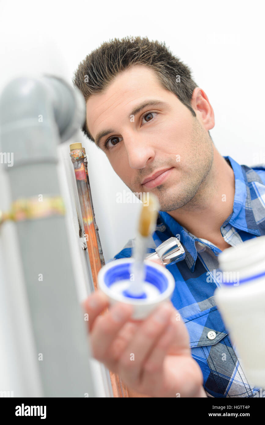 Plumber using some glue Stock Photo - Alamy