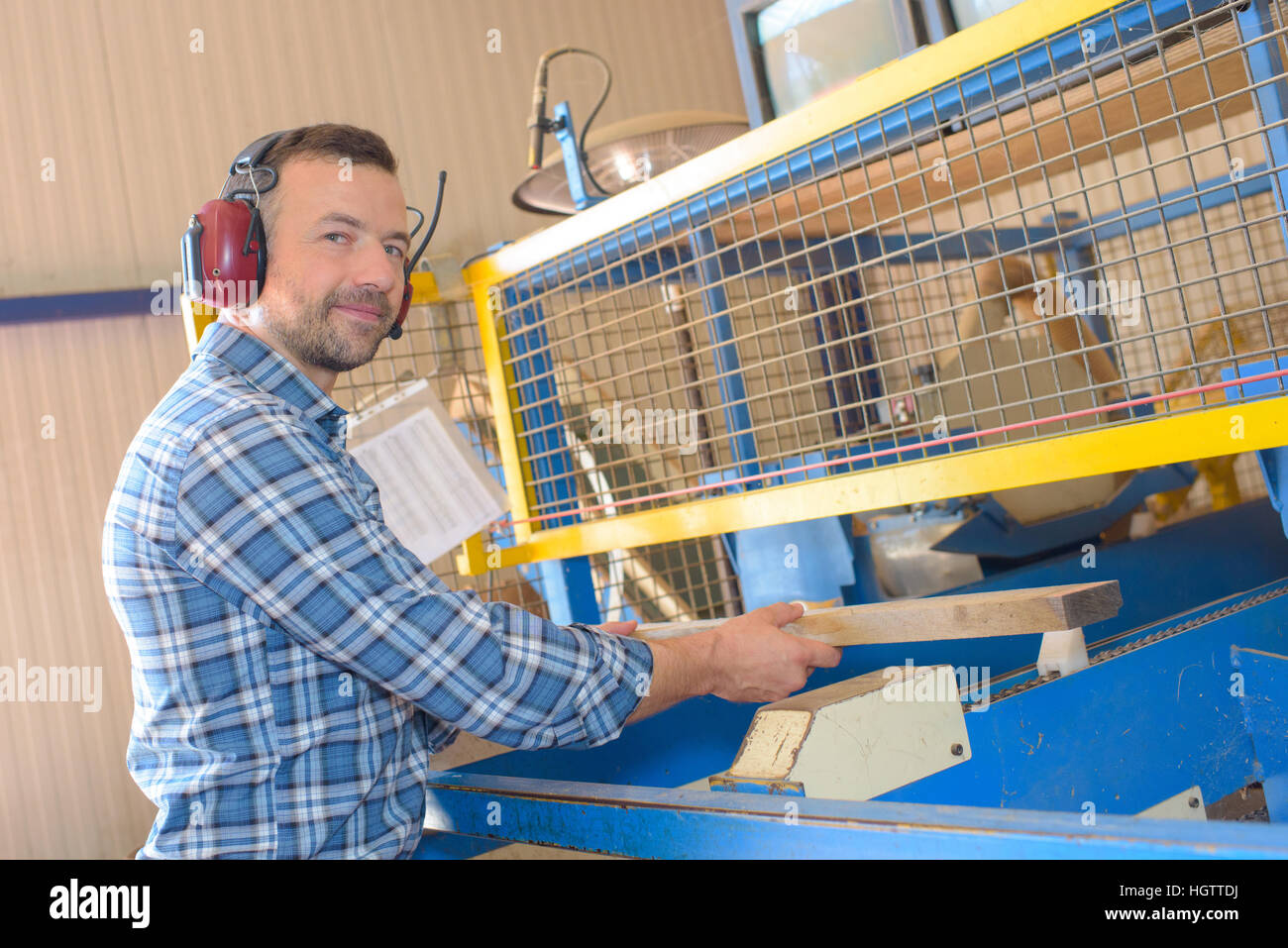 Man working with wood behind screen Stock Photo - Alamy