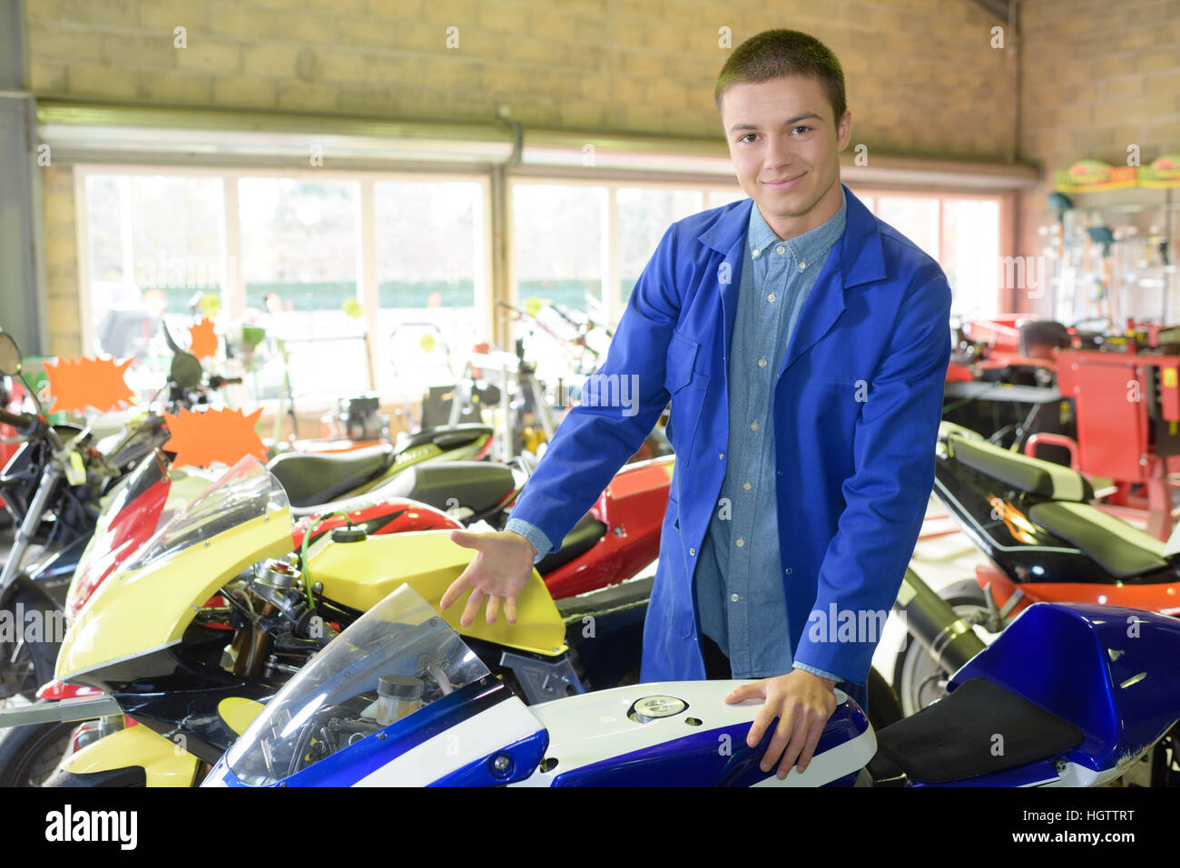 Man presenting motorcycle in shop Stock Photo - Alamy