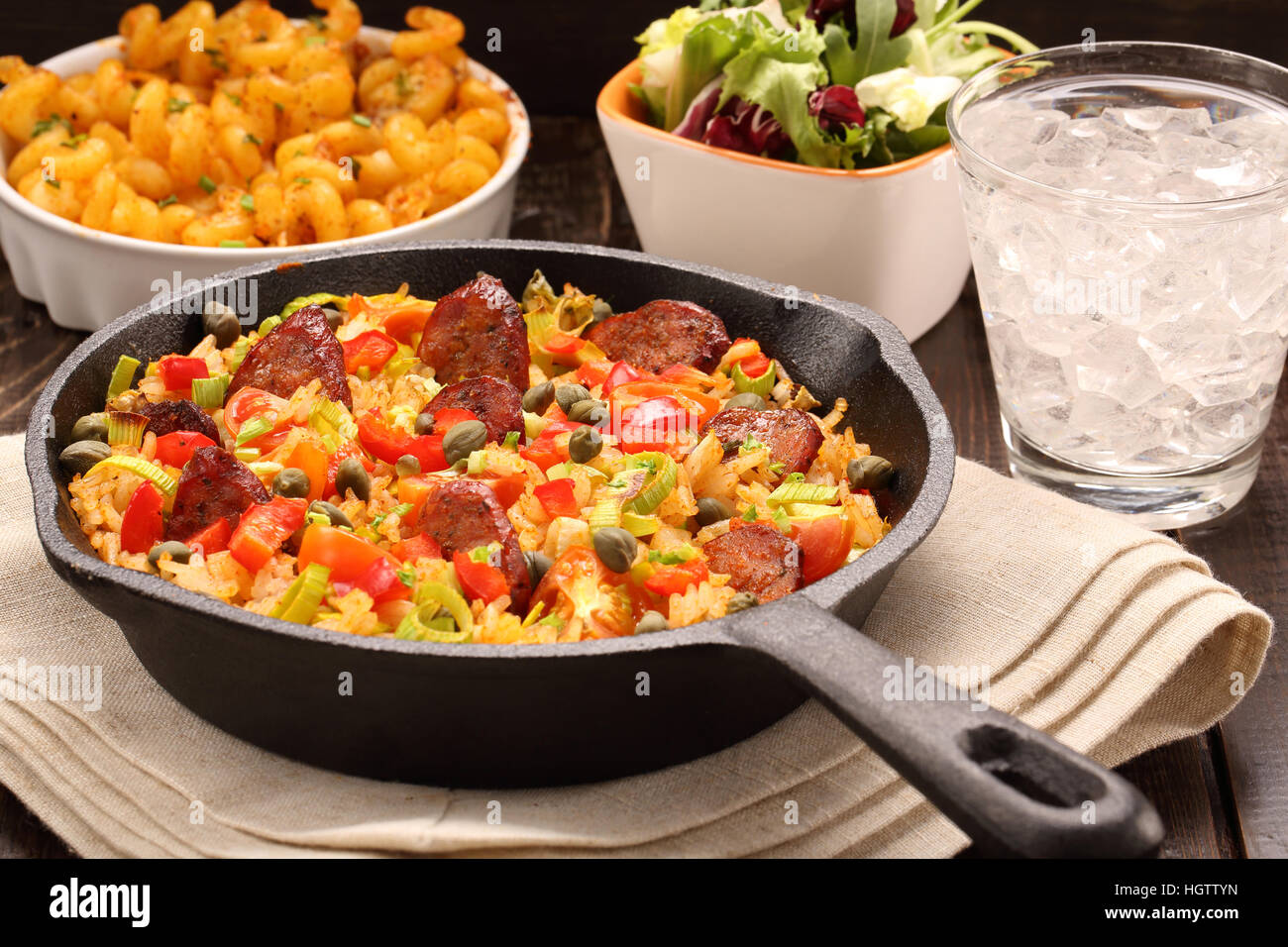 Rice with chorizo sausage and vegetables baked in a pan on wooden ...