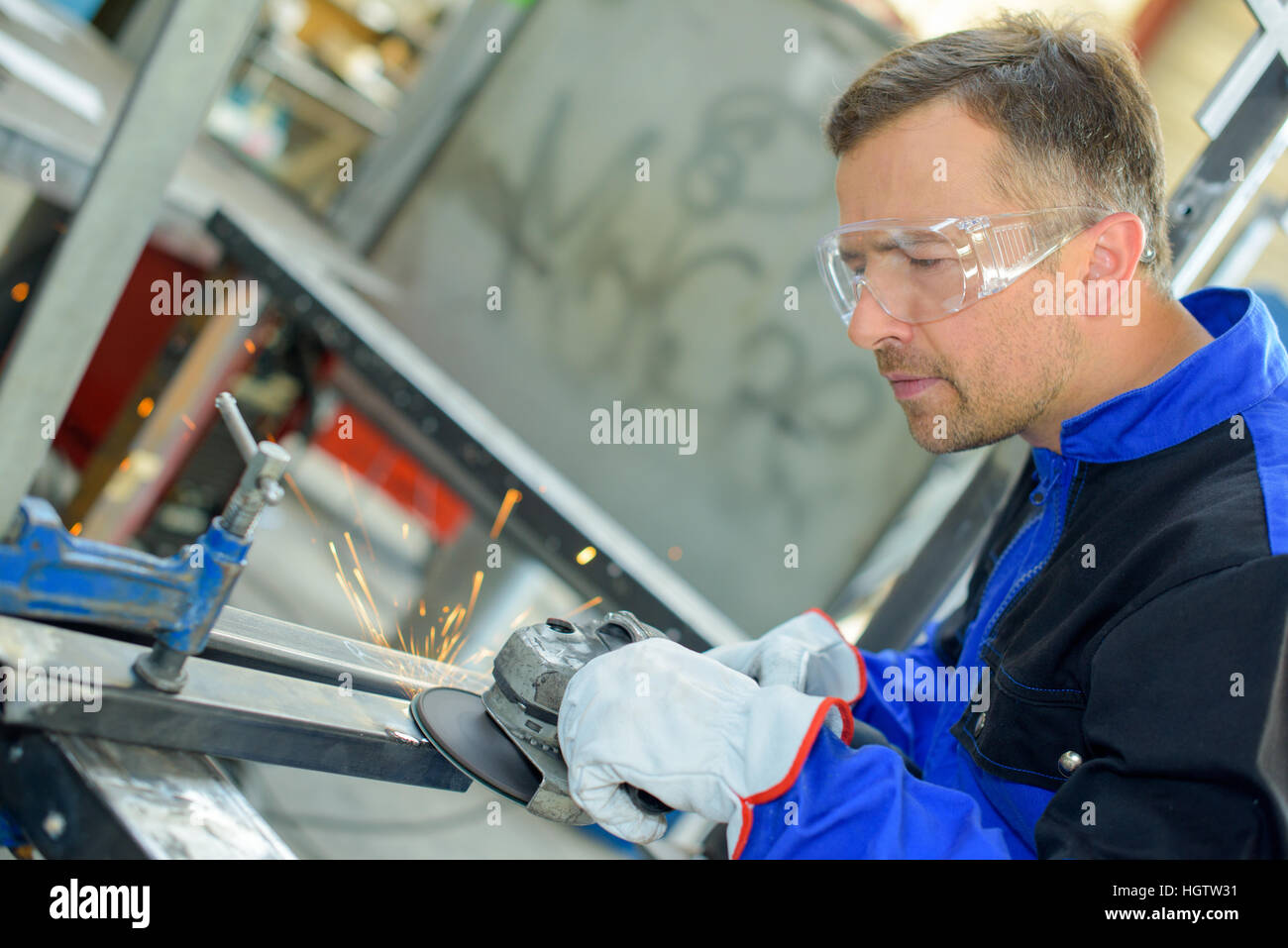 Workman using angle grinder Stock Photo - Alamy