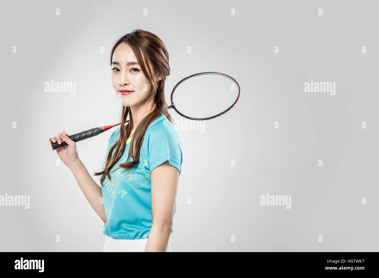 Side view of young smiling female badminton player Stock Photo - Alamy