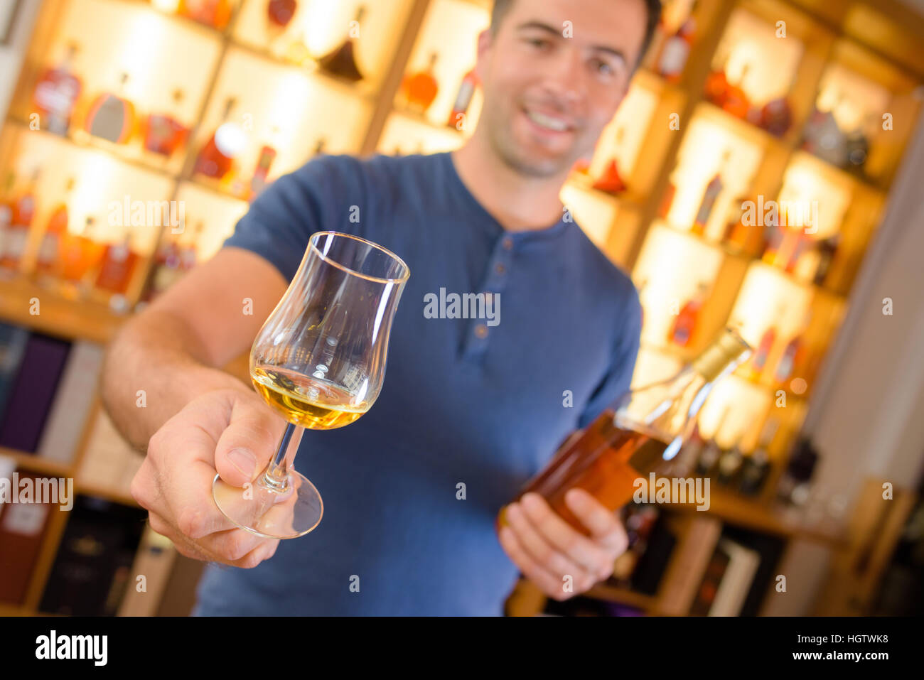 Man holding forward a glass of brandy Stock Photo - Alamy