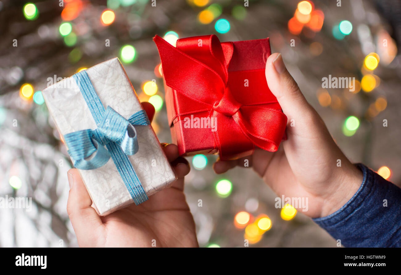 Man holding two presents with colorful background Stock Photo - Alamy