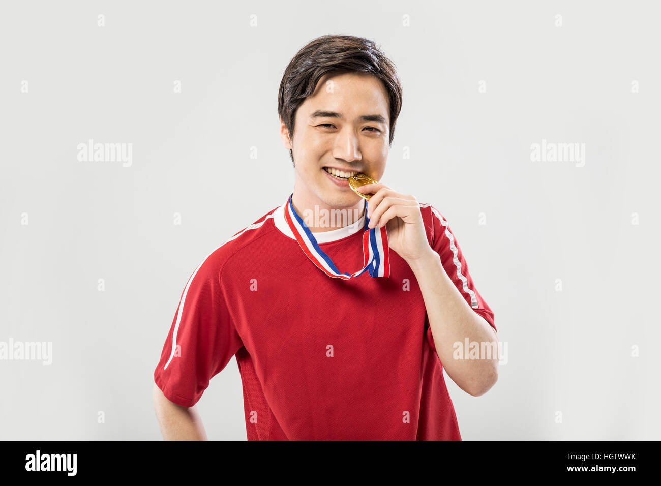 Portrait of young smiling Korean male sports player winning gold medal ...