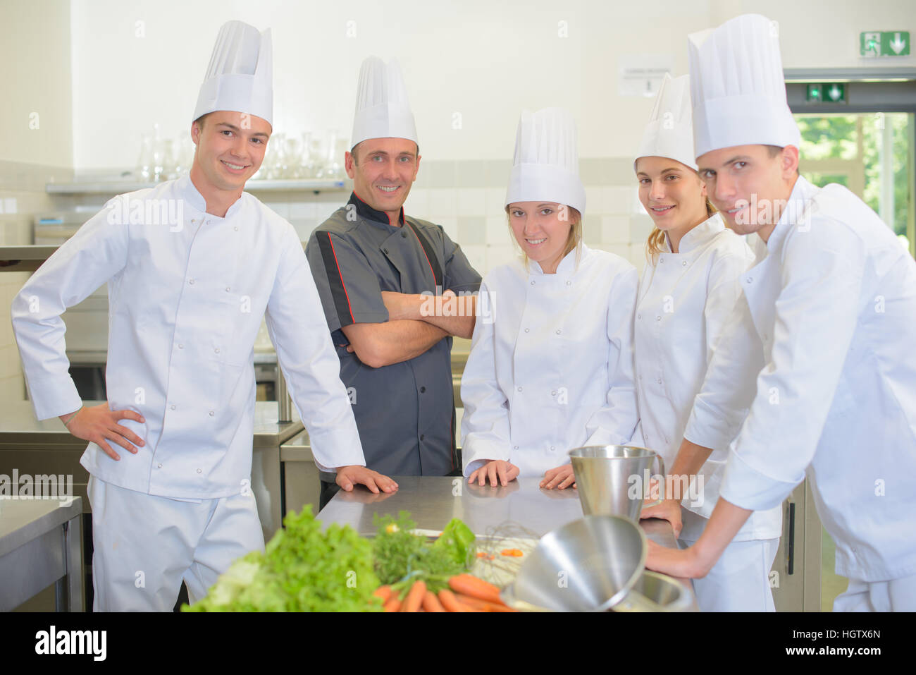 Portrait of chef with his student chefs Stock Photo - Alamy